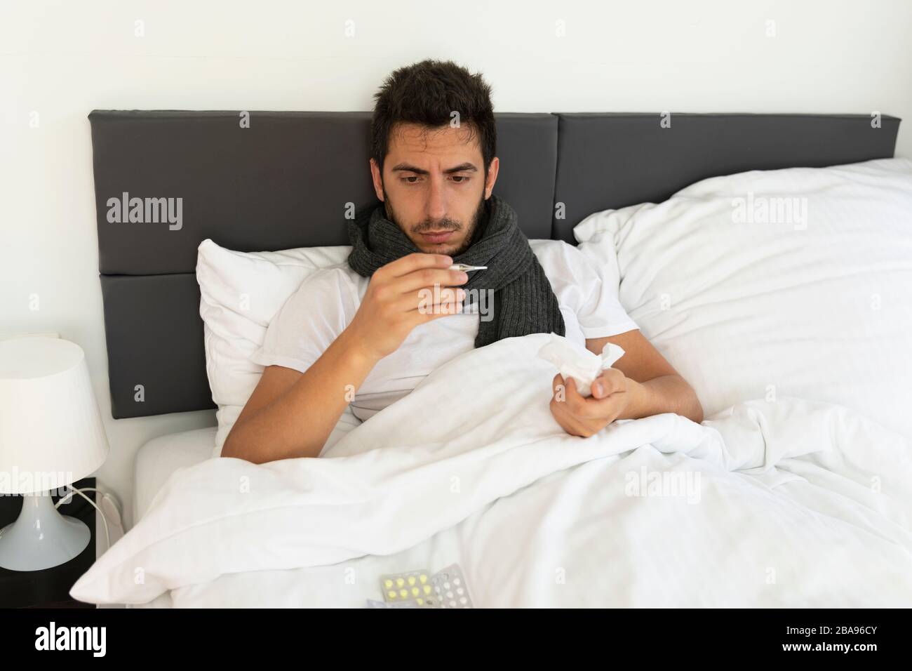 The man is sick, he has a fever and a cough. He is at home and trying ...