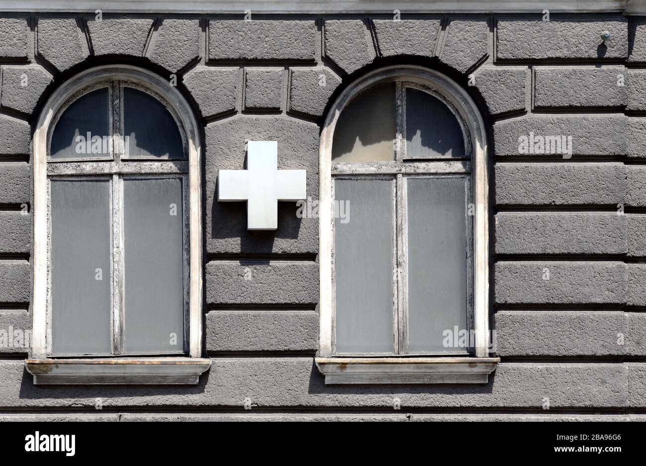 A historic pharmacy facade with arched windows and a white medical ...