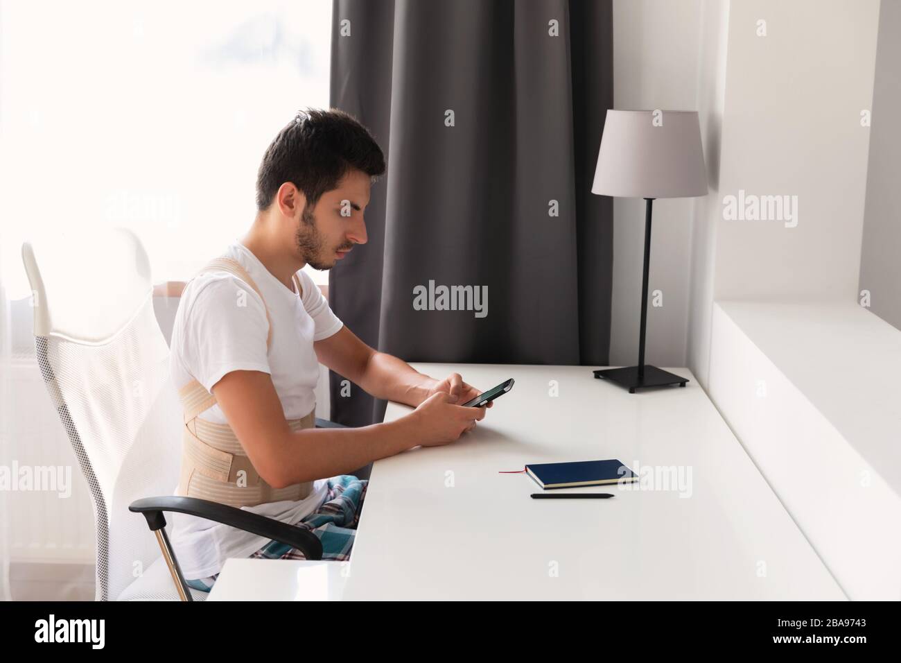 Young man wearing a back support belt. Lumbar brace, back support for ...