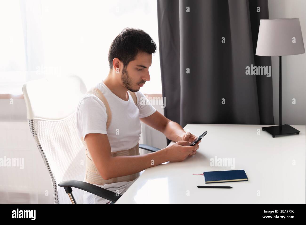 Young man wearing a back support belt. Lumbar brace, back support for ...