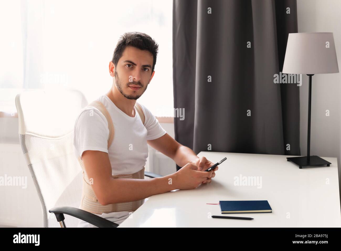 Young man wearing a back support belt. Lumbar brace, back support for ...