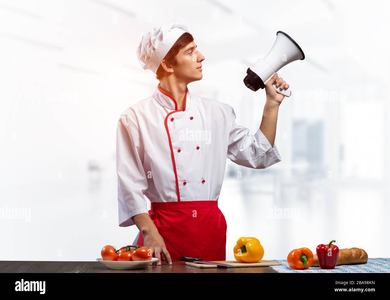 Young chef standing with megaphone in hand Stock Photo - Alamy