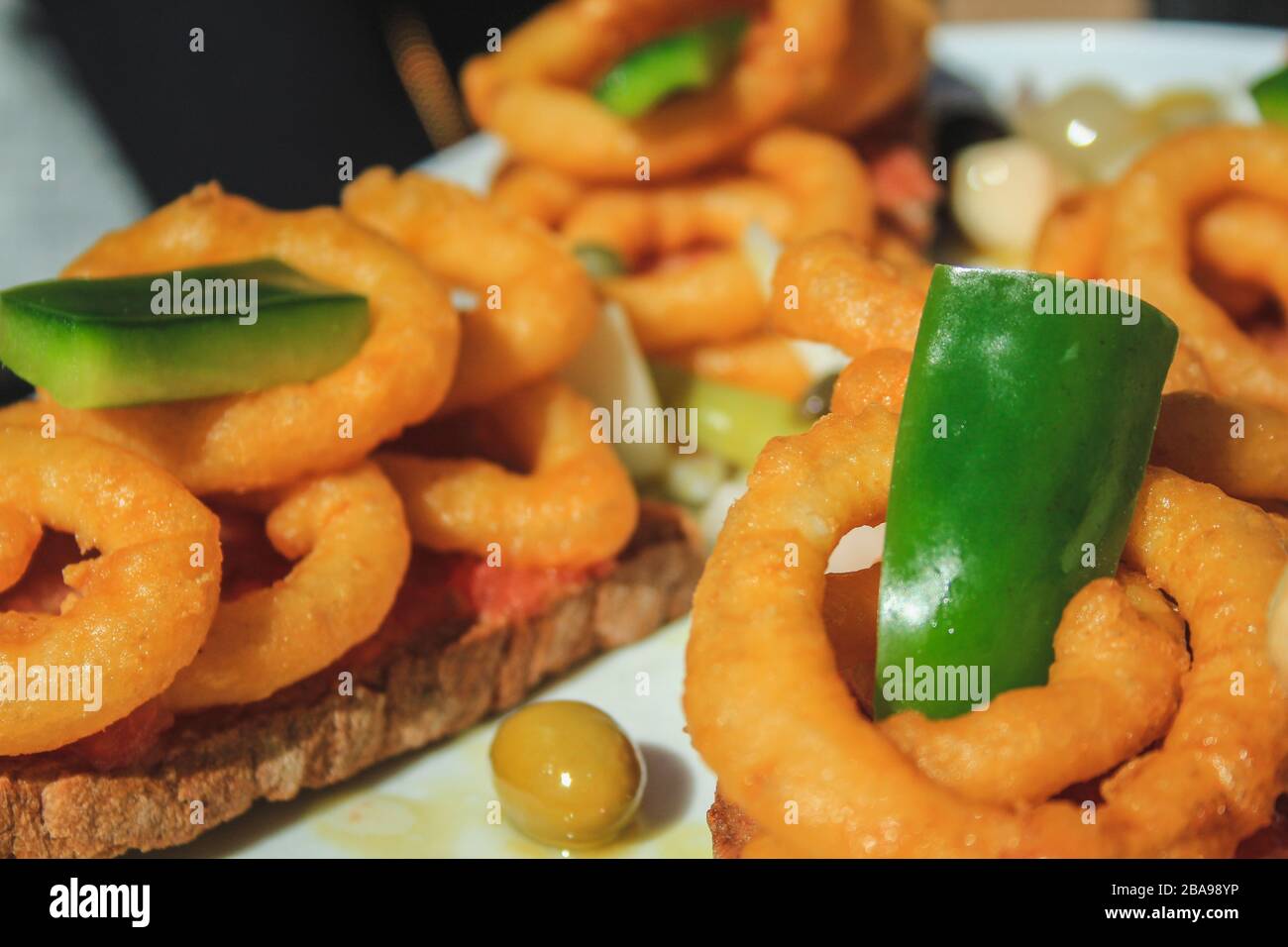 Traditional spanish tapas - gold fried calamari rings on crusty bread ...