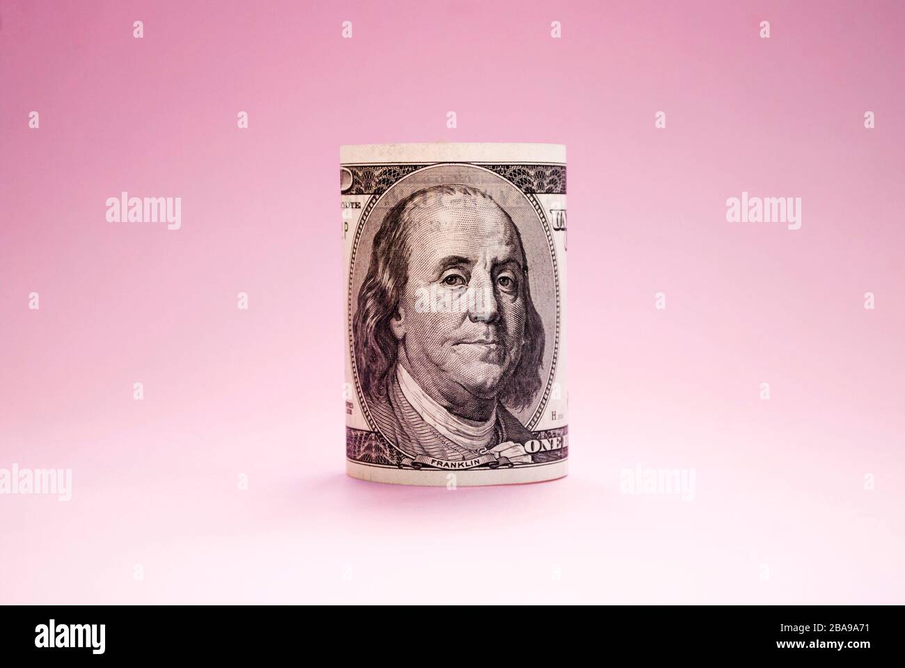 Rolled up bill on a pink background. 100 dollars. Money Stock Photo - Alamy