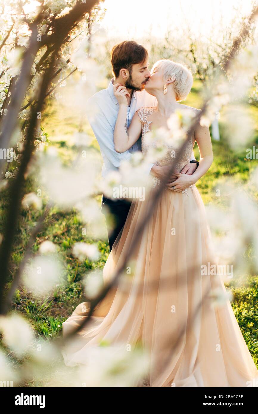 Beautiful romantic kissing Caucasian couple in spring blooming garden ...