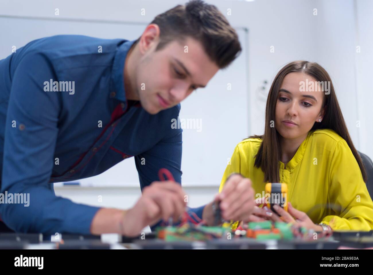 Two young handsome engineers working on electronics components.Tech ...