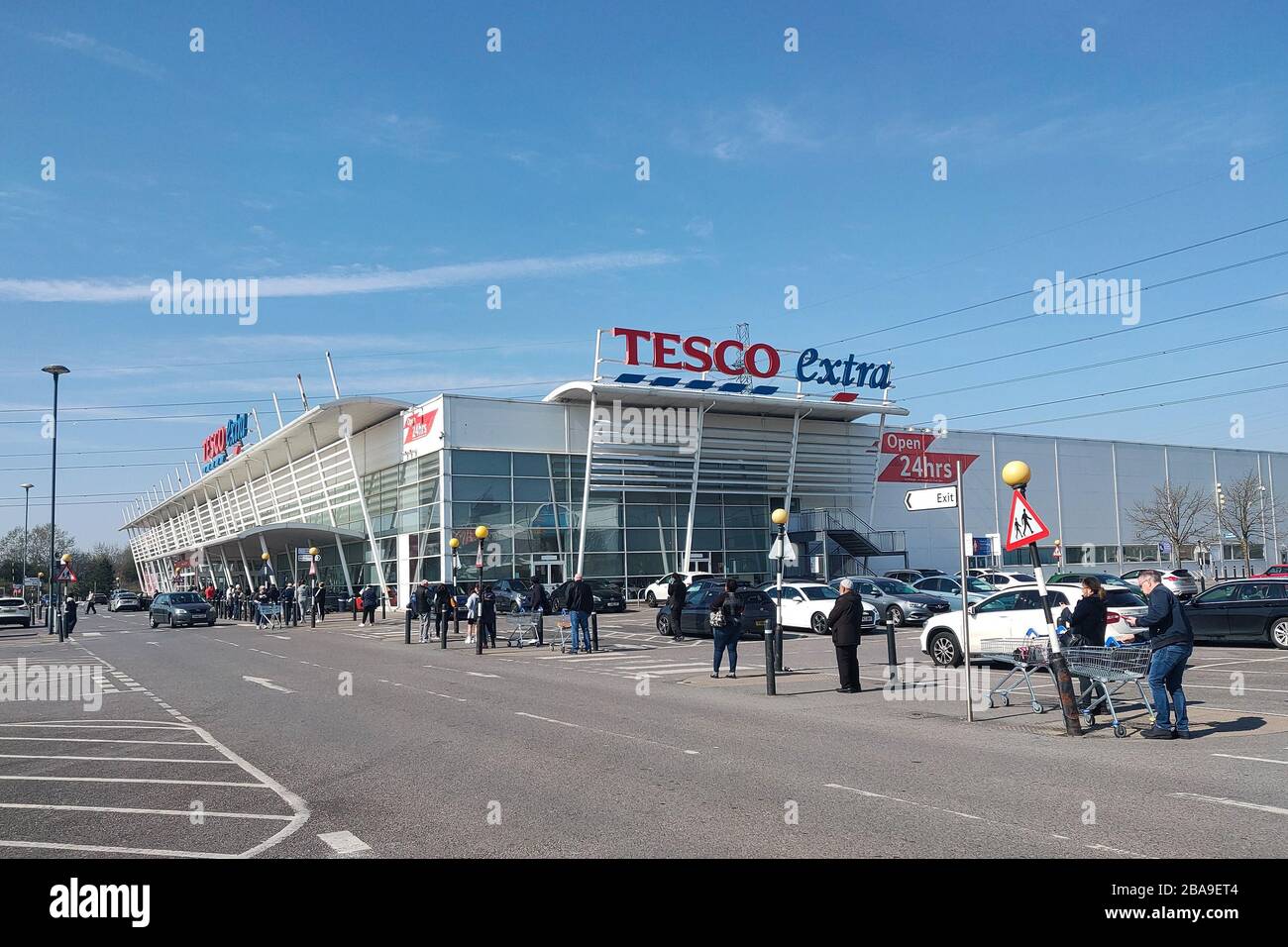 Shoppers queueing at a Tesco Superstore observing social distancing ...