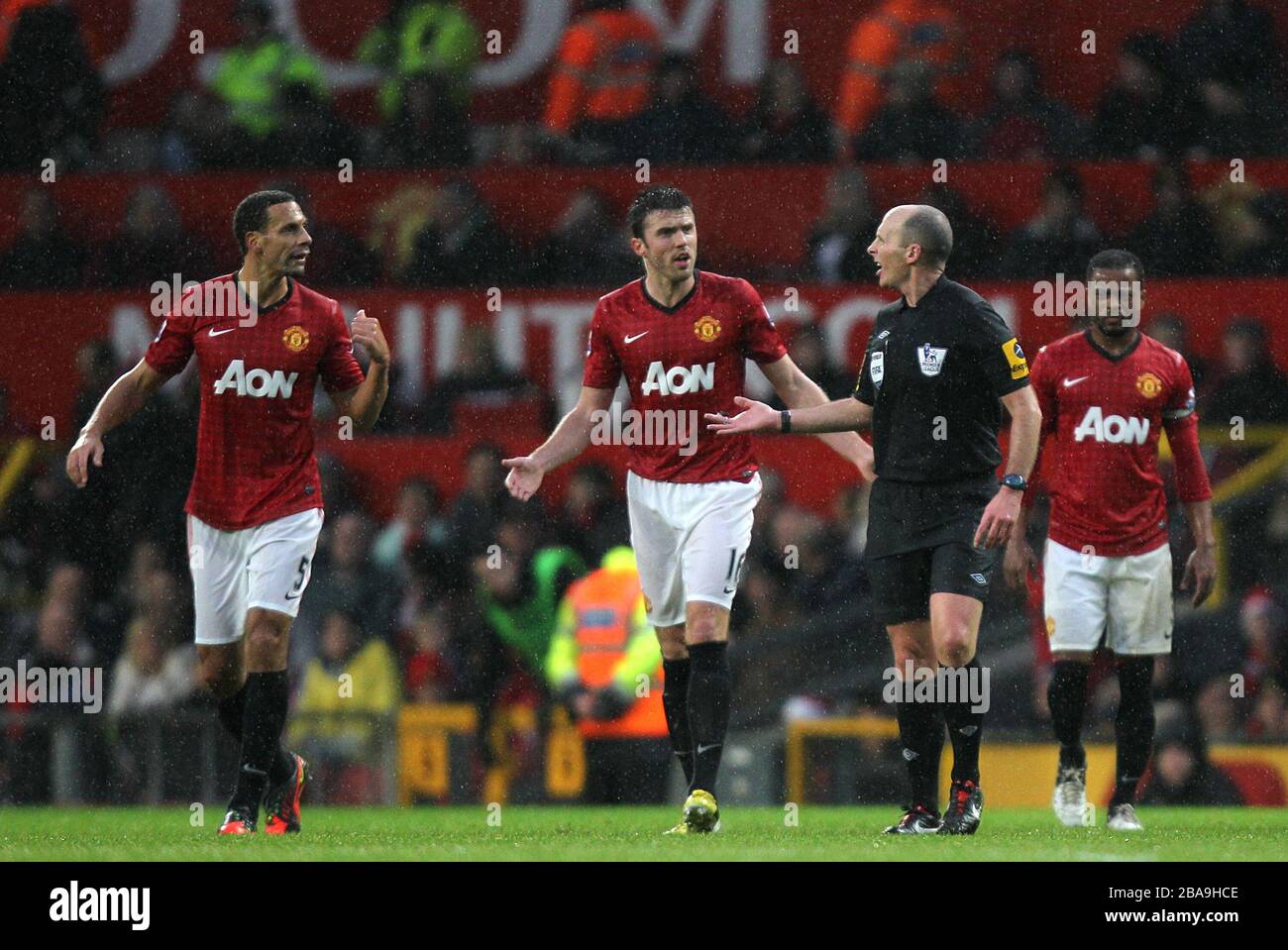 Referee Mike Dean (second right) is surrounded by Manchester United ...