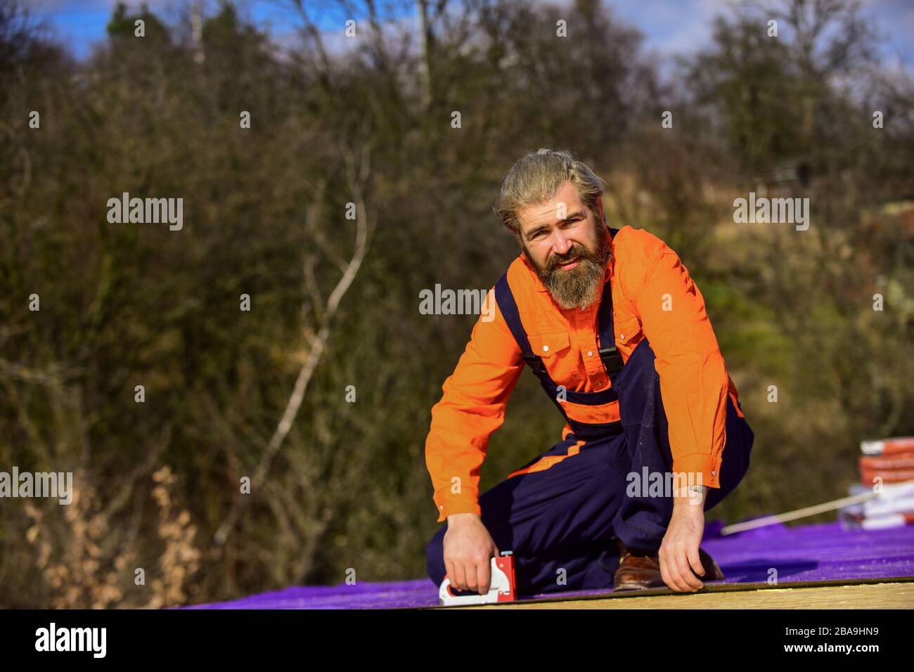 Roof installation. Bearded man work outdoor. Roof Mechanic concept ...