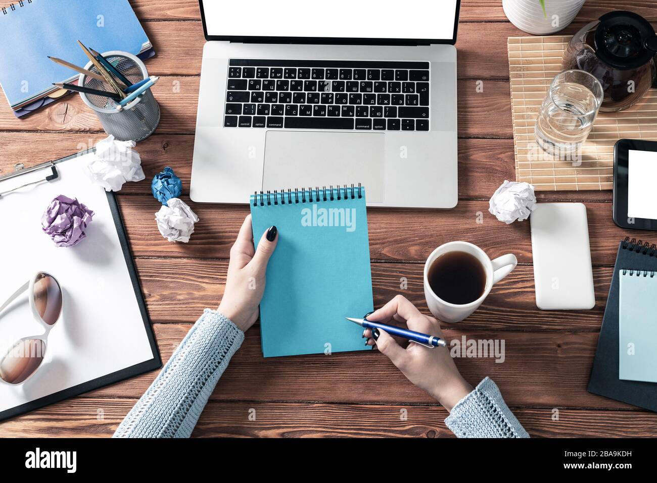 Female student taking notes with pen at desk Stock Photo - Alamy