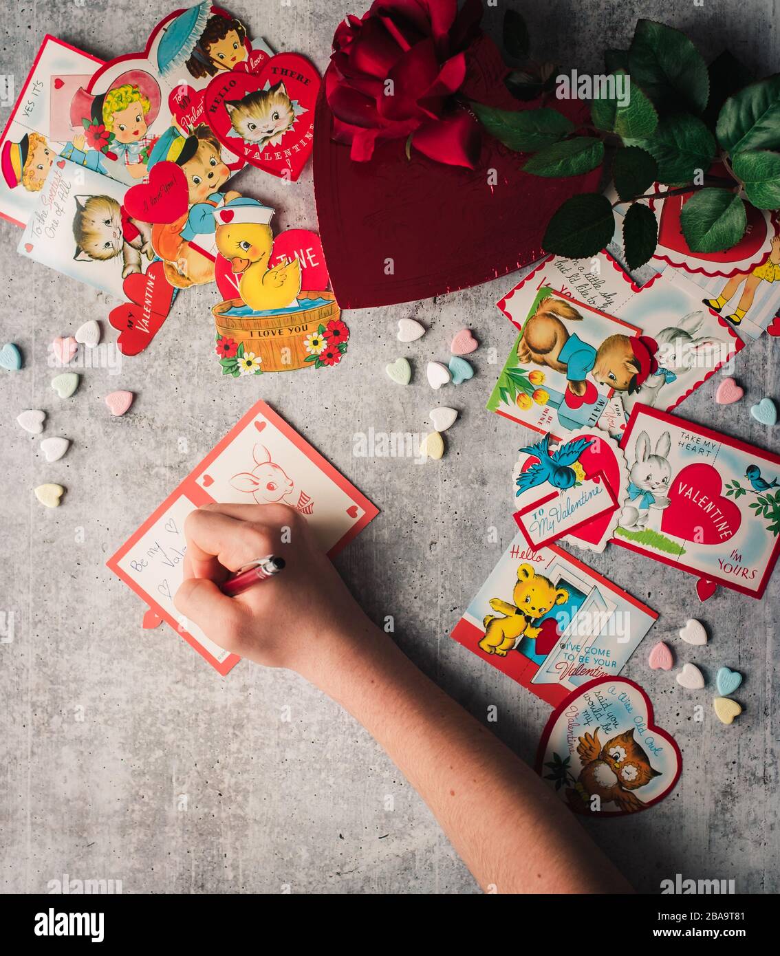 Hand signing vintage Valentine's cards with a rose and candy Stock ...