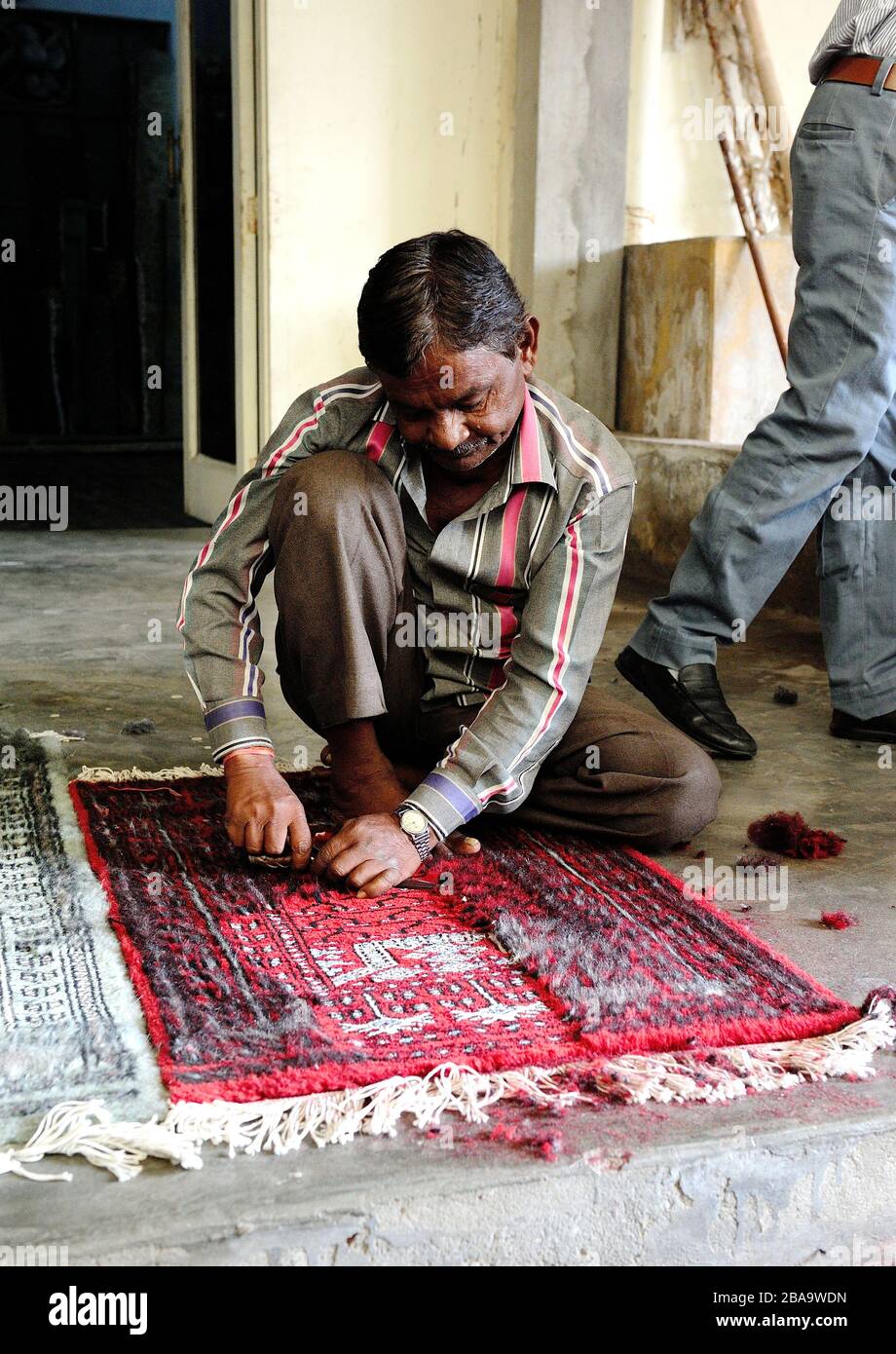 Jaipur, India - 11th November 2019:Hand cutting the new rug to show the ...