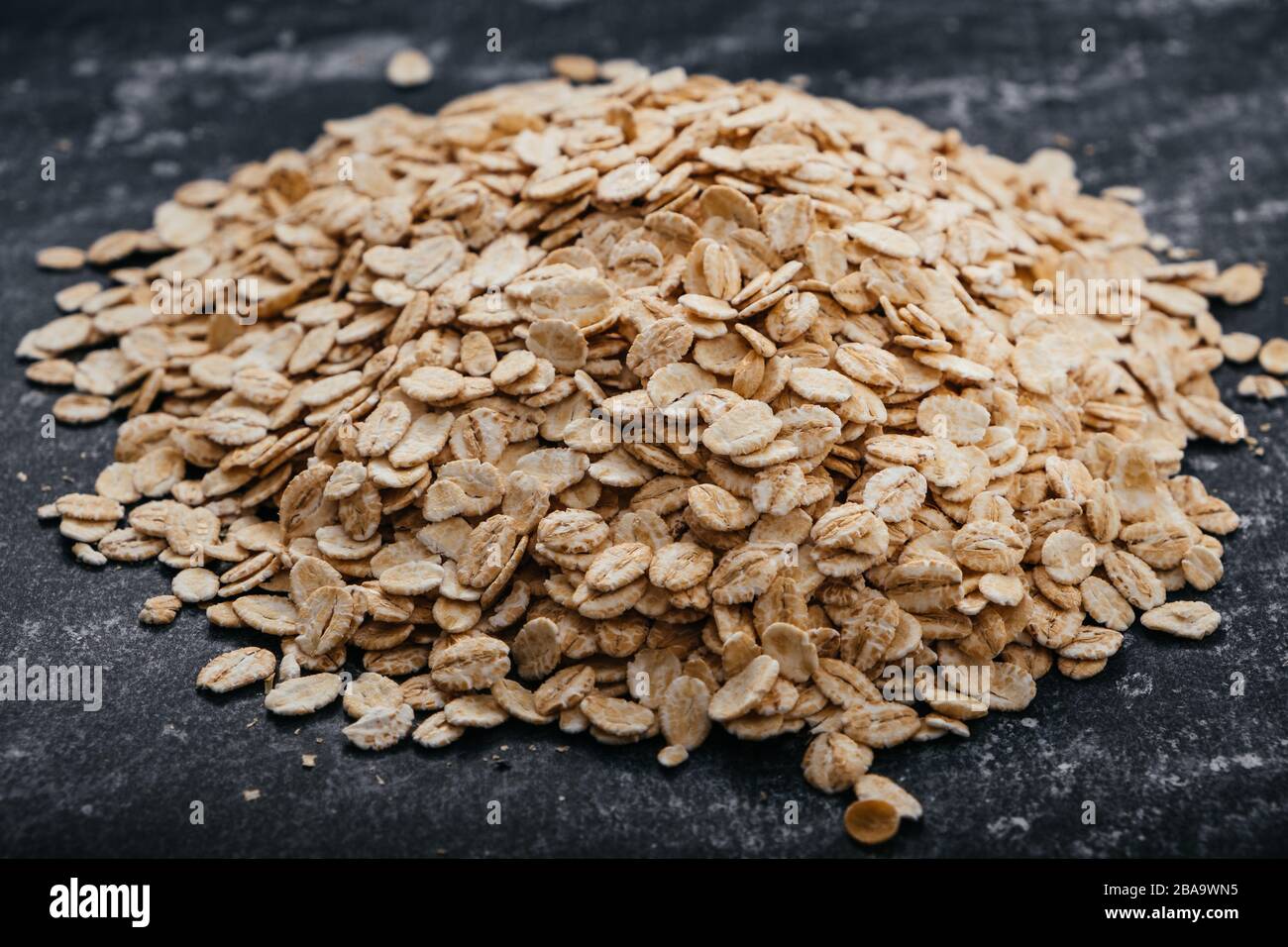 Pile of oat flakes on a black background Stock Photo - Alamy