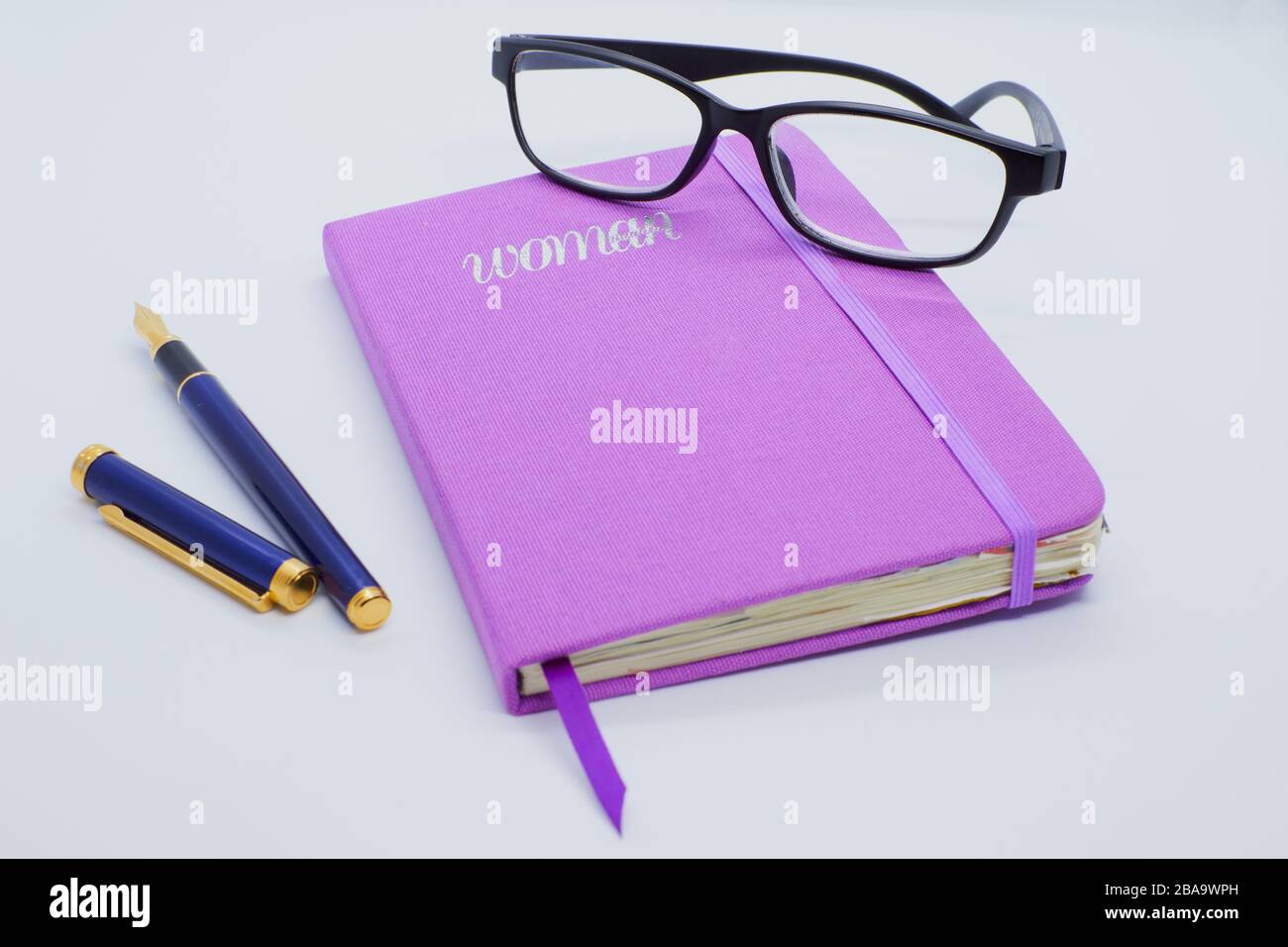 Purple diary for writing of woman with blue and purple pen and black ...