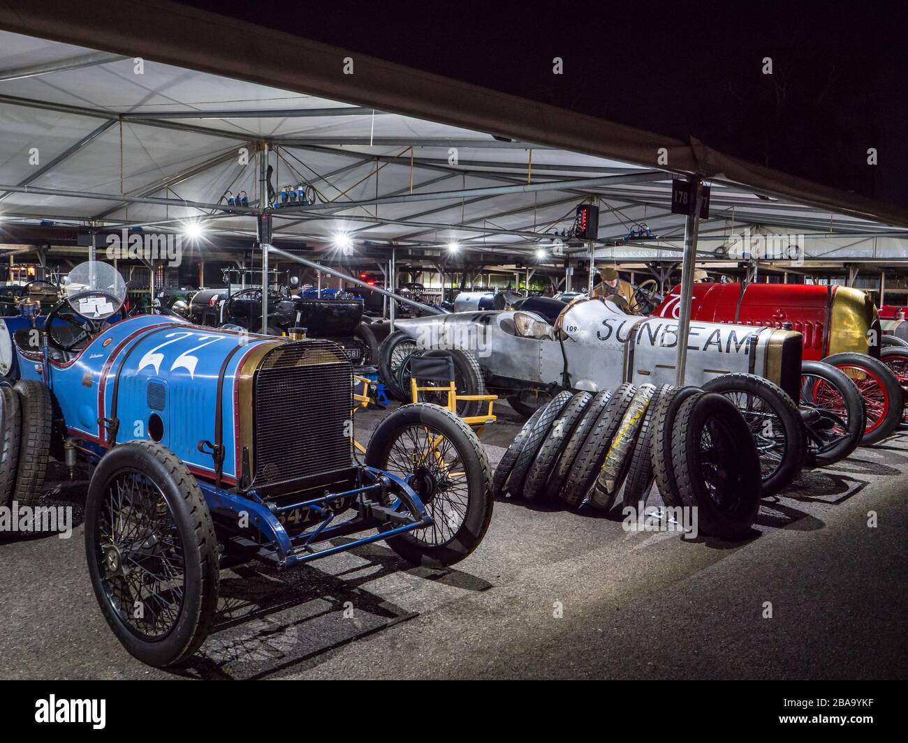 Vintage Edwardian racing cars parked in the paddock area at night, at ...