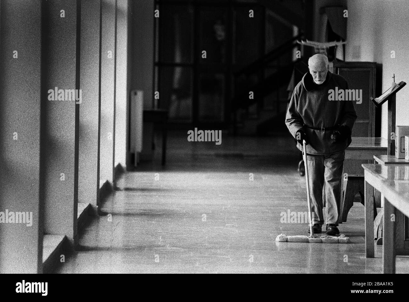 A monk cleaning the floor in a corridor at Sancta Maria Abbey at Nunraw ...