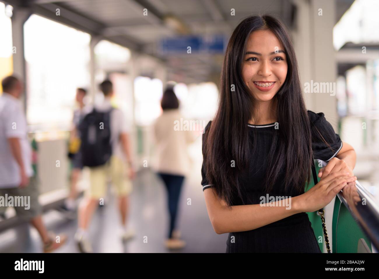 Happy young beautiful Asian tourist woman thinking on the footbridge ...