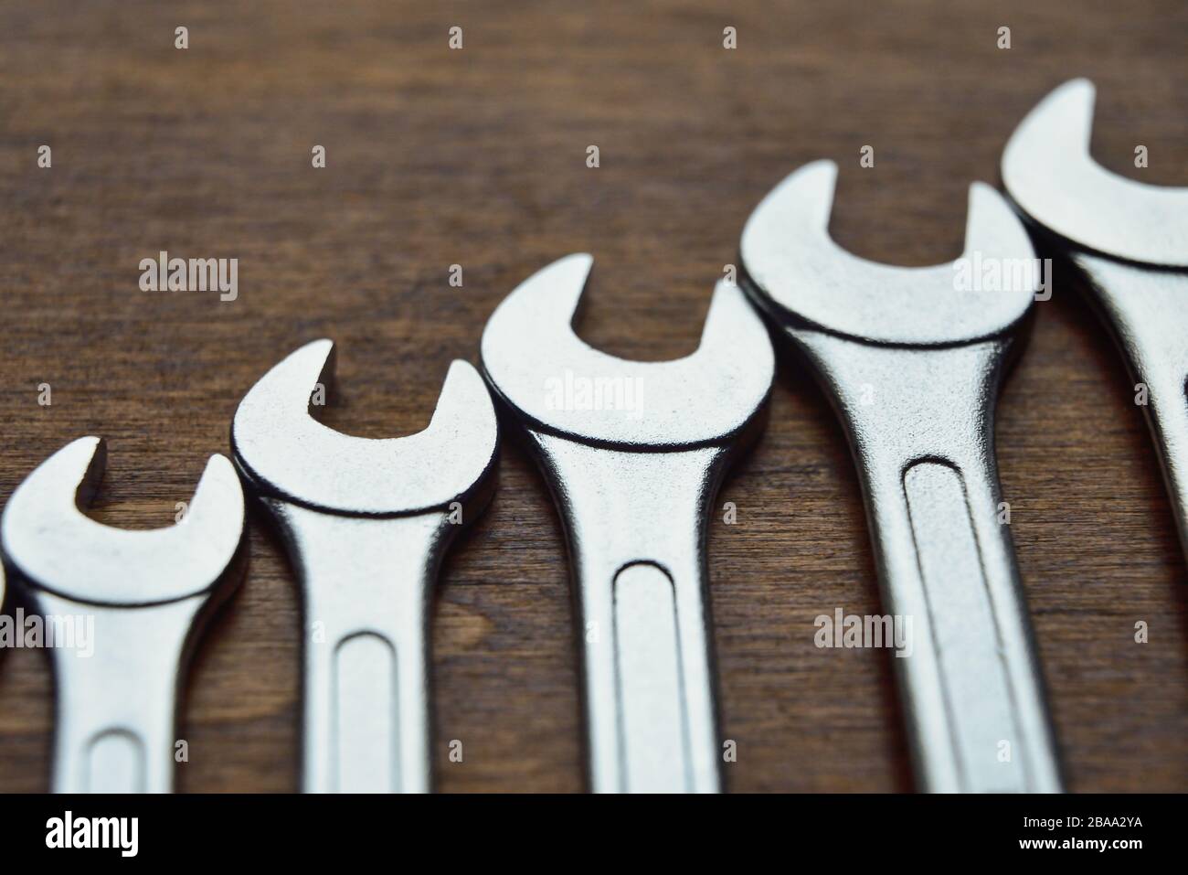 Some metal wrenches on a wood background Stock Photo - Alamy