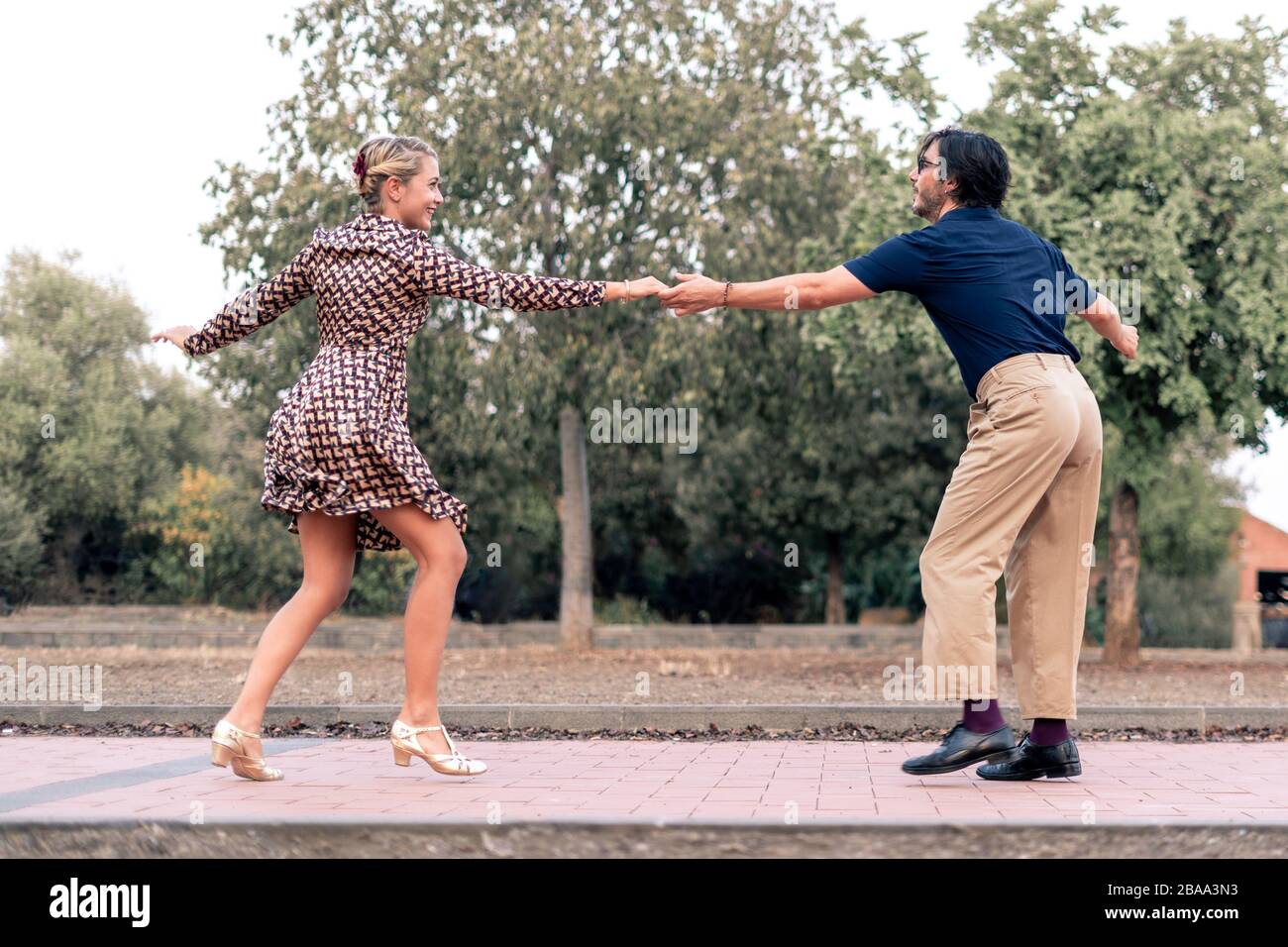 Couple of swing dancers having fun dancing in the park outdoors ...