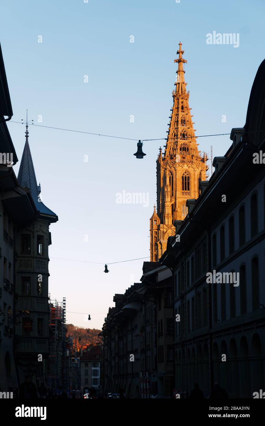 View of gold color Cathedral of Bern and silhouette of street at sunset ...