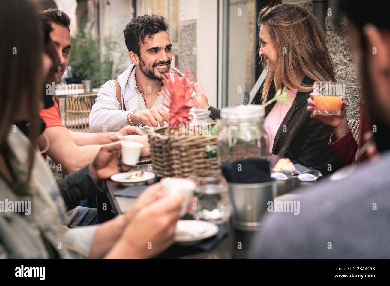 Multiracial friends, girls and guys, having fun laughing drinking ...