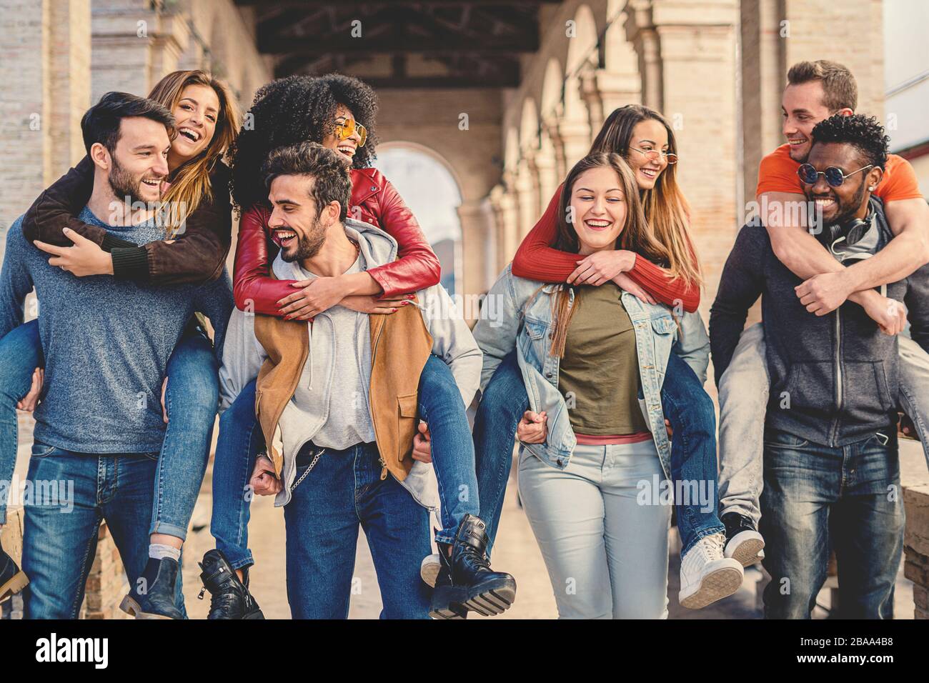 Group of friends having fun under the arcades of the historic center ...