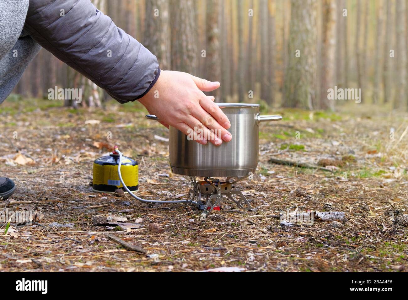 Camper is cooking dinner in a metal pan during camping. Enjoy a tasty ...