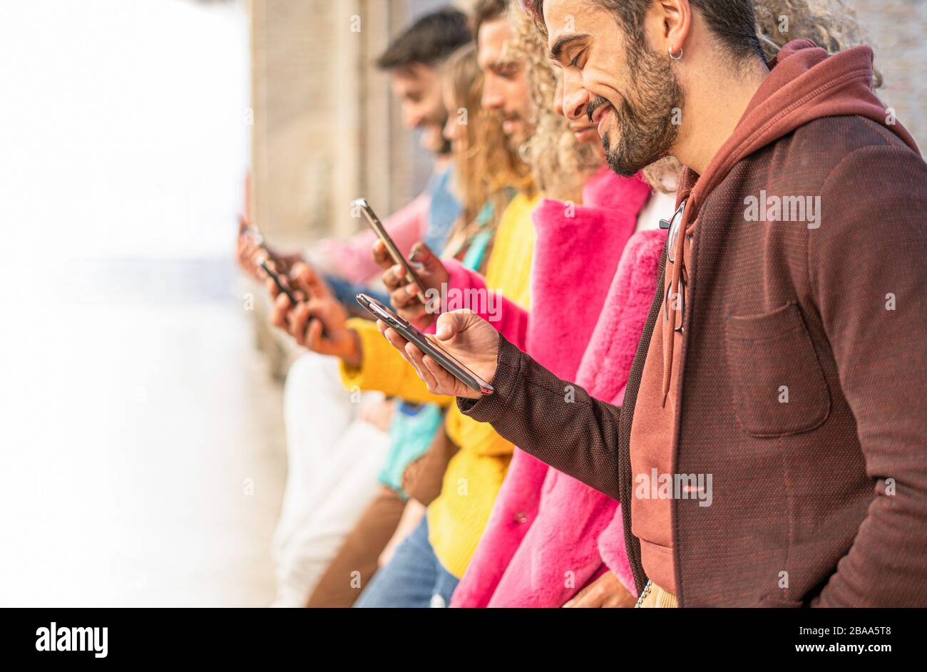 Group of multiracial people standing watching with their cell phones ...