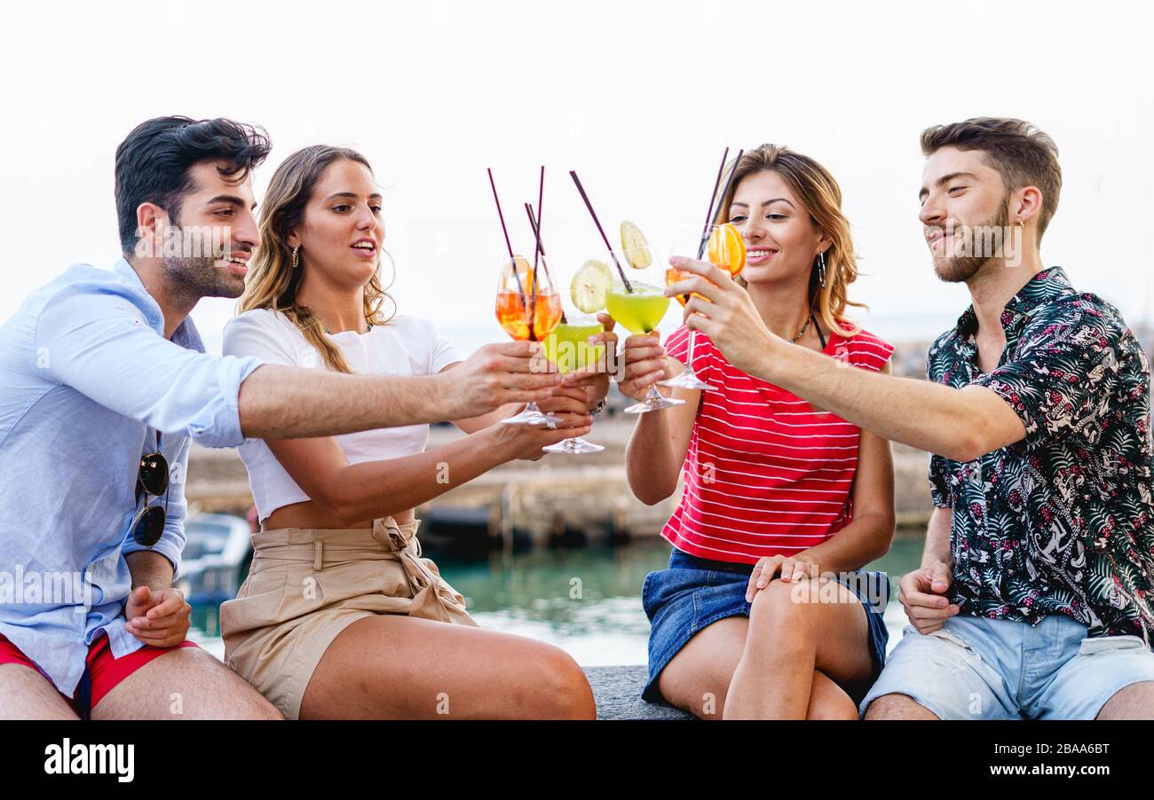 Friends toasting, saying cheers holding tropical blended fruit ...