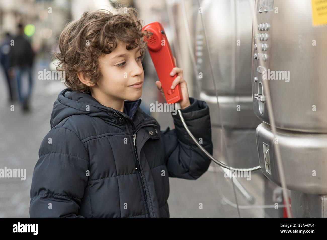 7 years old kid talking on a public payphone in the street Stock Photo ...