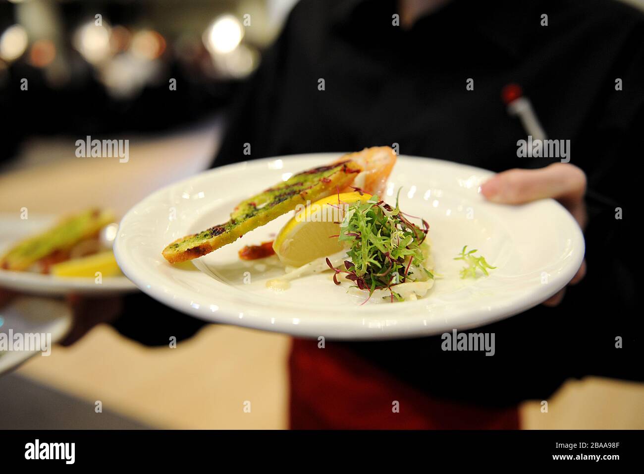 Waiting staff deliver food to guest's tables Stock Photo - Alamy