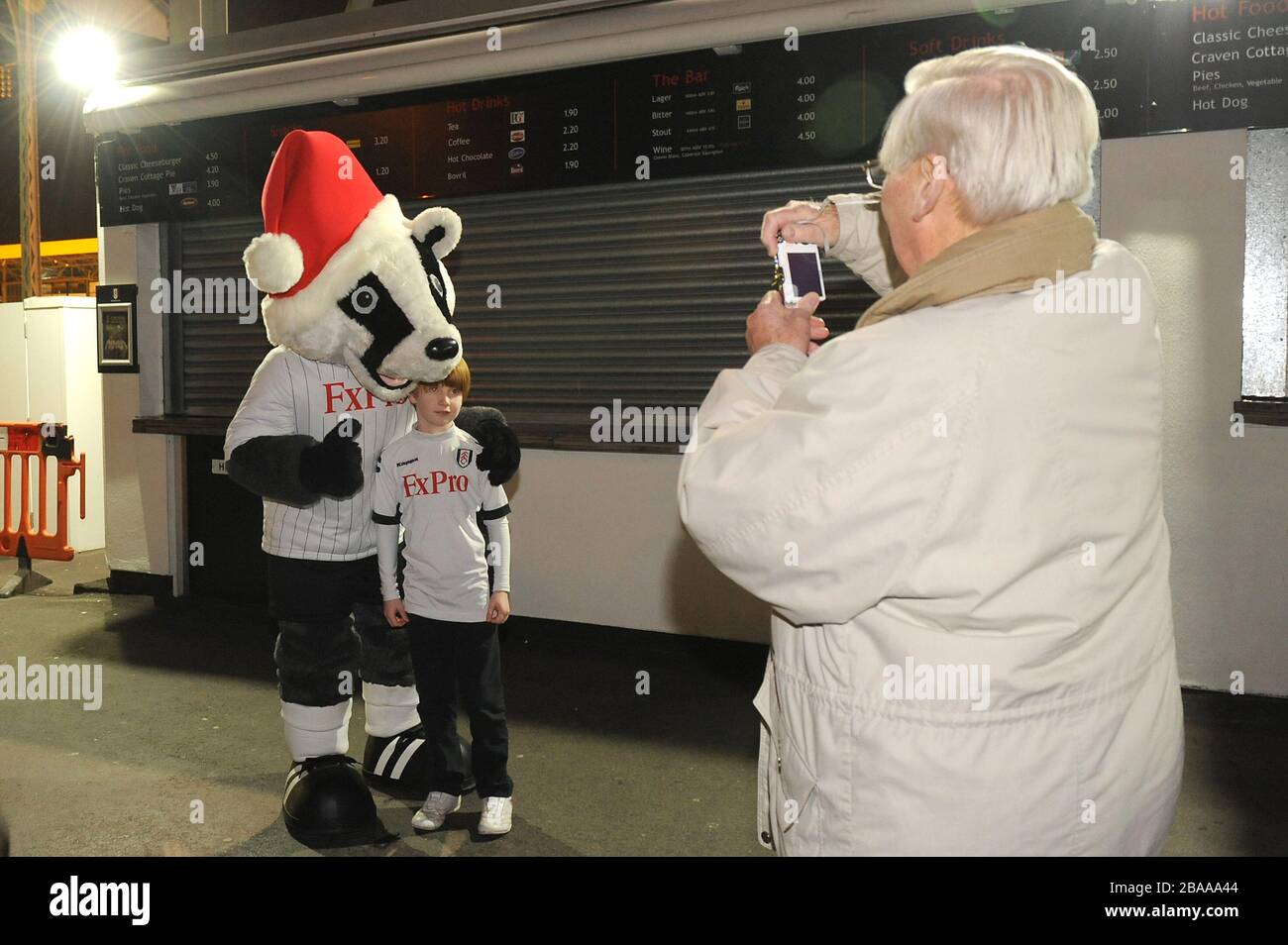 Fulham mascot Billy the Badger poses for photographs with a young fan ...