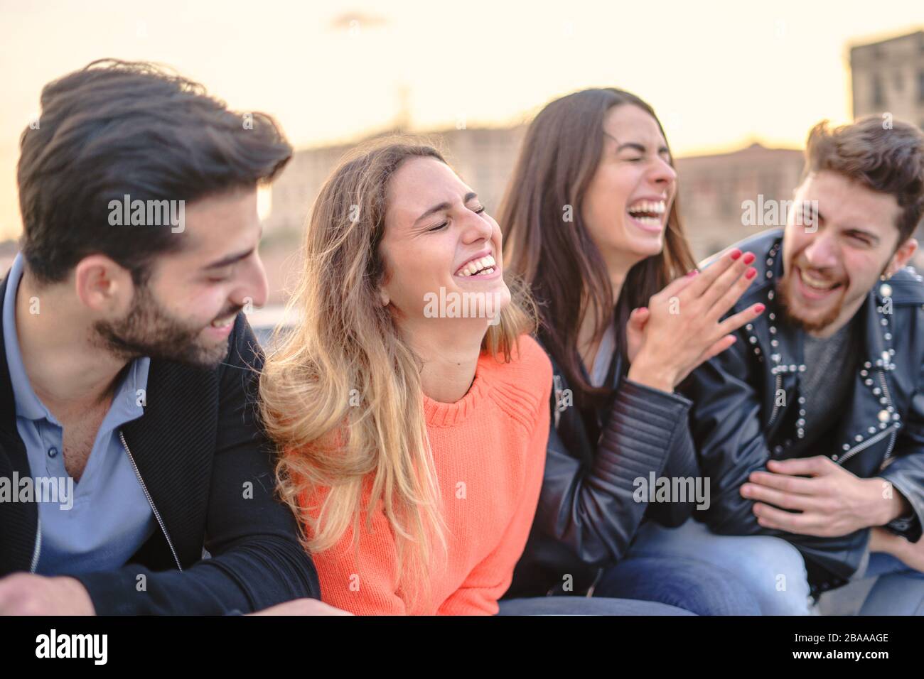 group of young friends having fun joking, laughing and chatting ...
