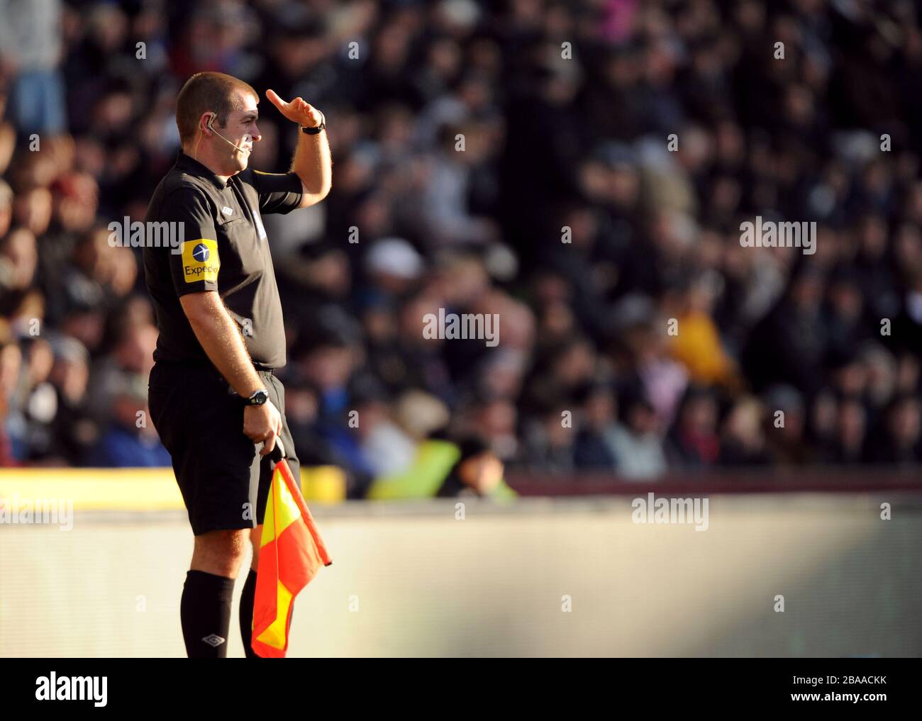 The assistant referee shields his eyes from the sun Stock Photo - Alamy