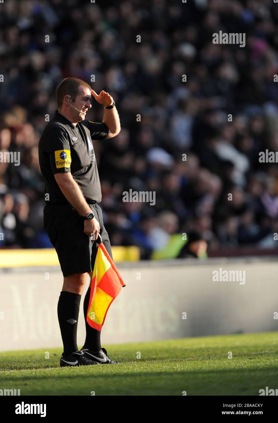 The assistant referee shields his eyes from the sun Stock Photo - Alamy