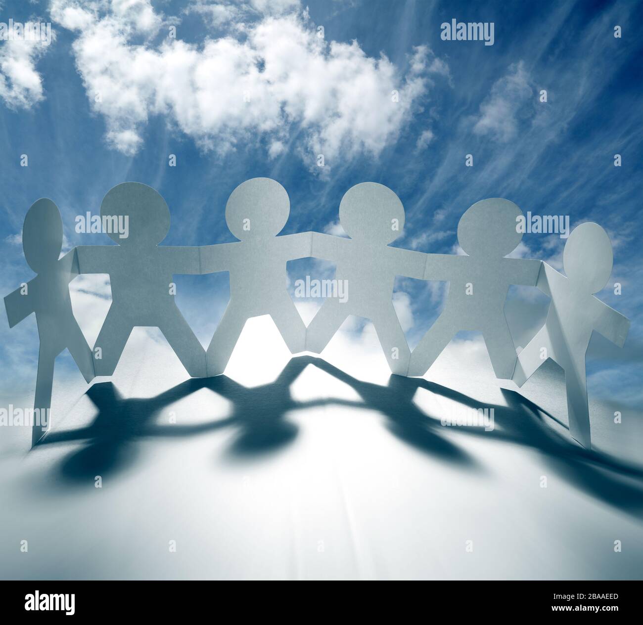Paper chain team holding hands. Teamwork. Partnership Stock Photo - Alamy