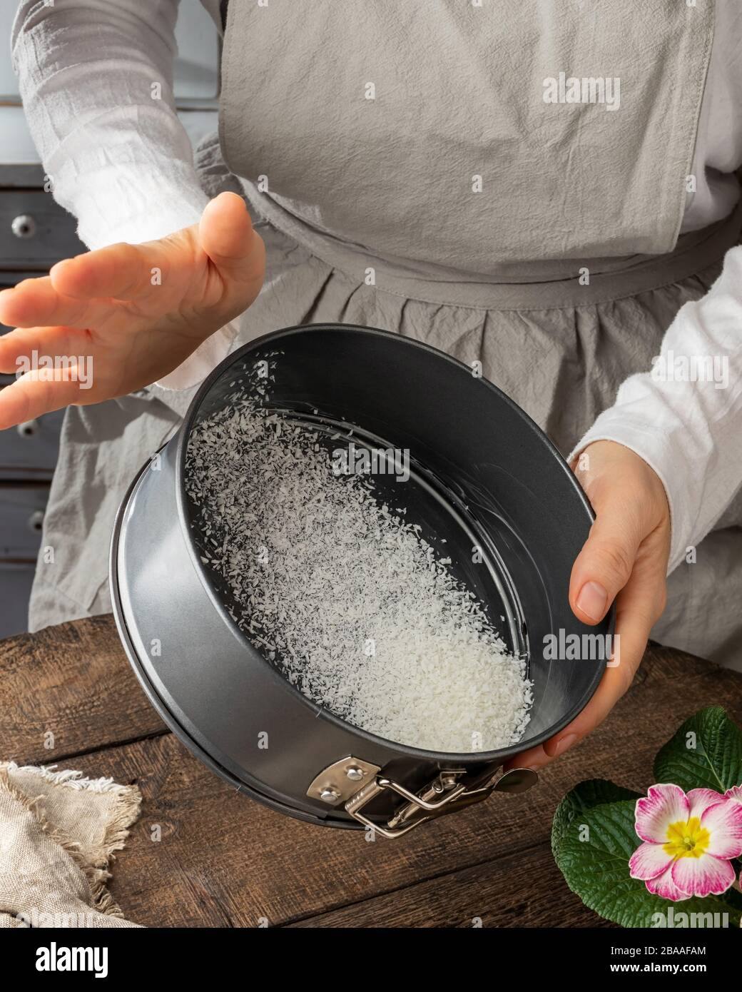 Preparation of a no-bake cake - dusting the greased baking mold with ...
