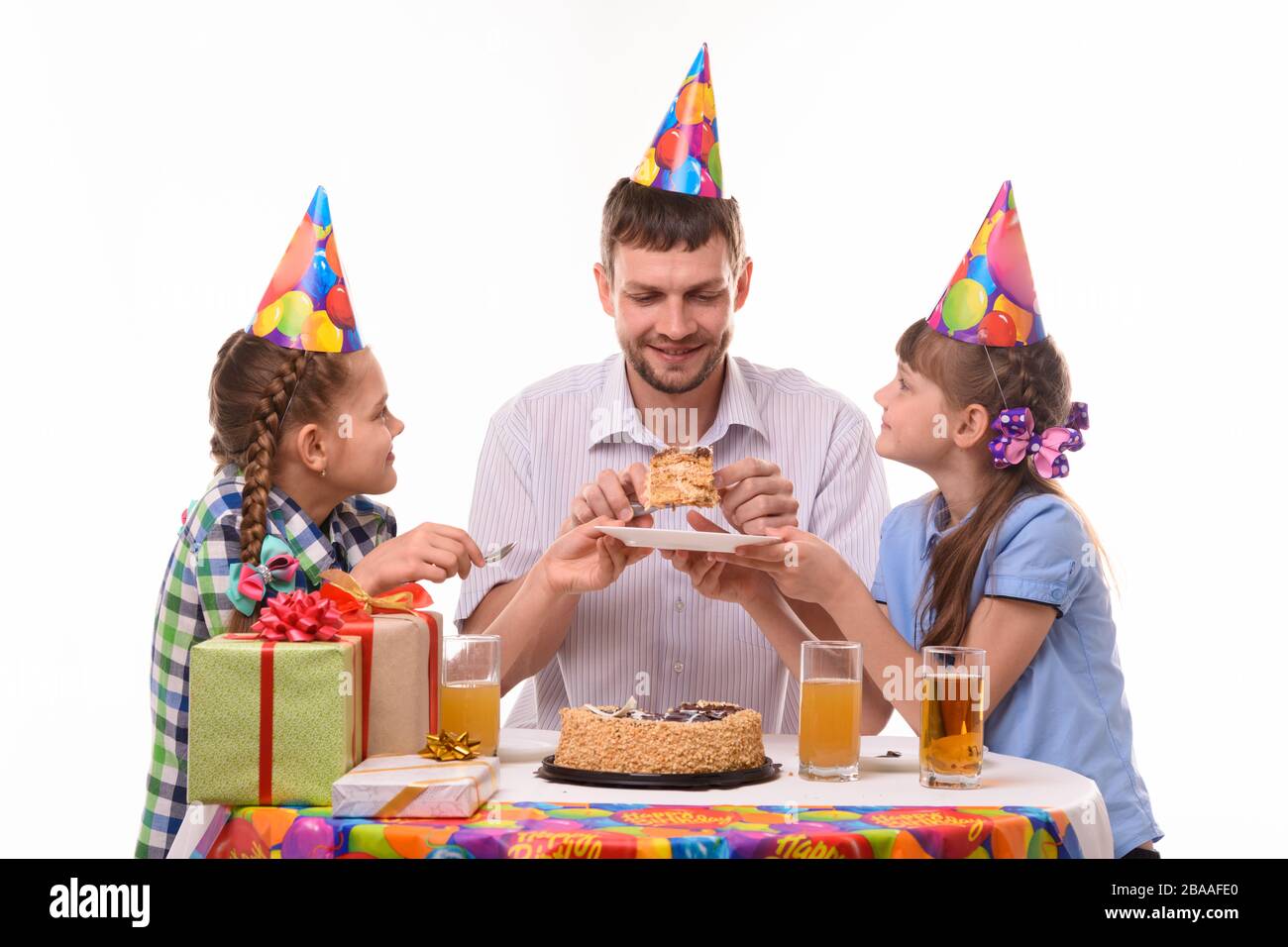 Children ask dad for their piece of holiday cake Stock Photo - Alamy