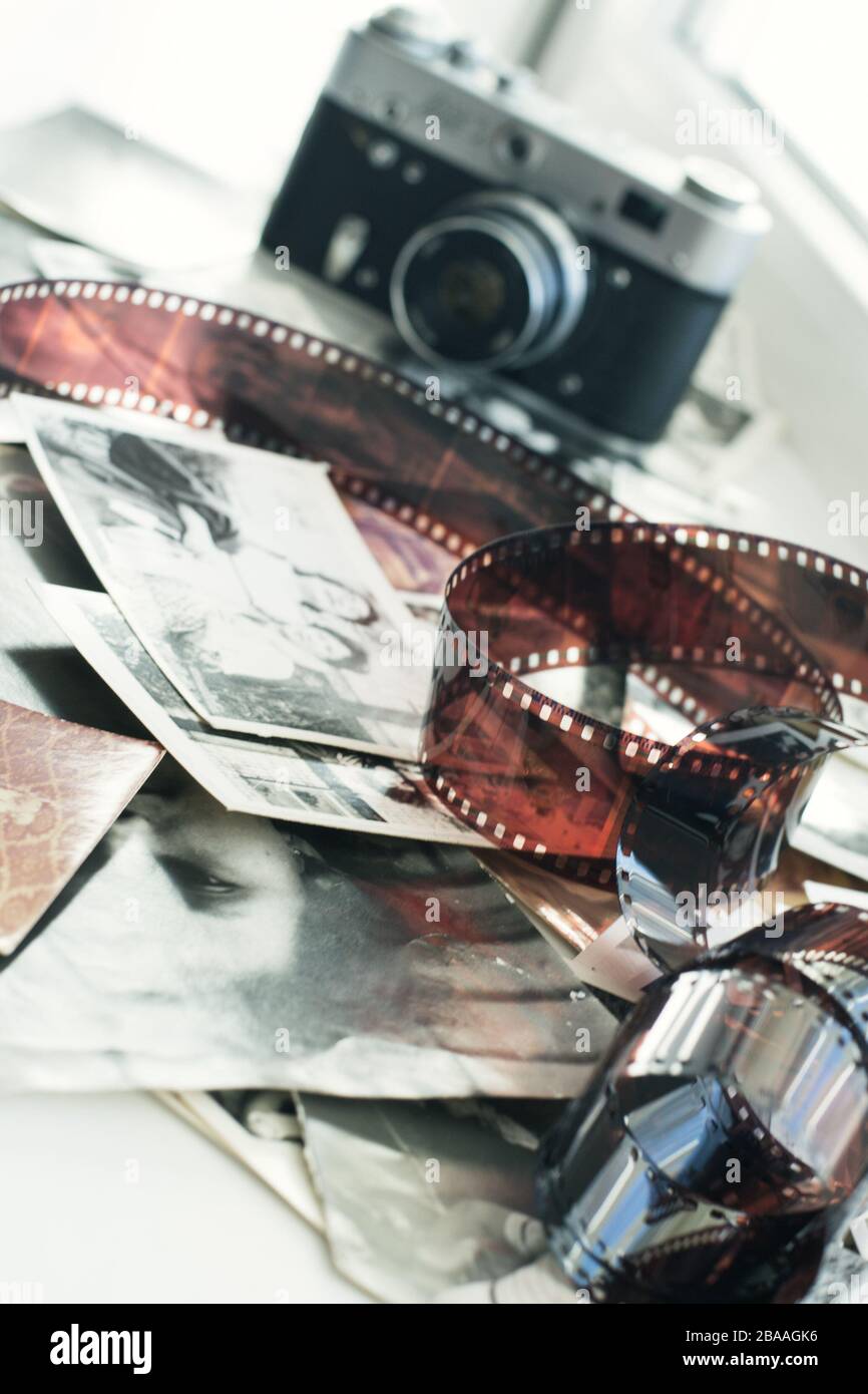 Old camera lies in photos next of photographic film Stock Photo - Alamy