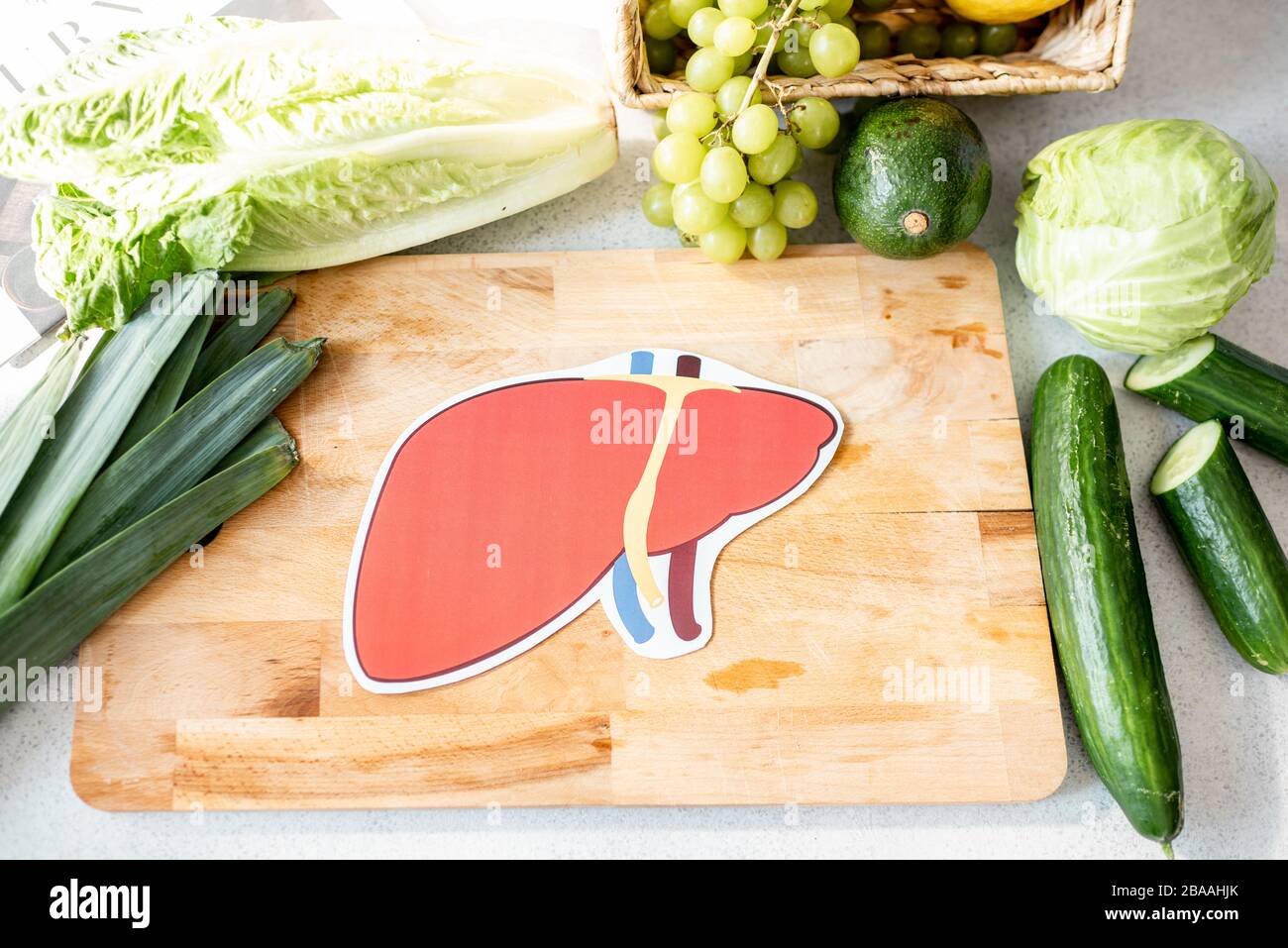 Human liver drawing on the cutting board with fresh green food, view ...