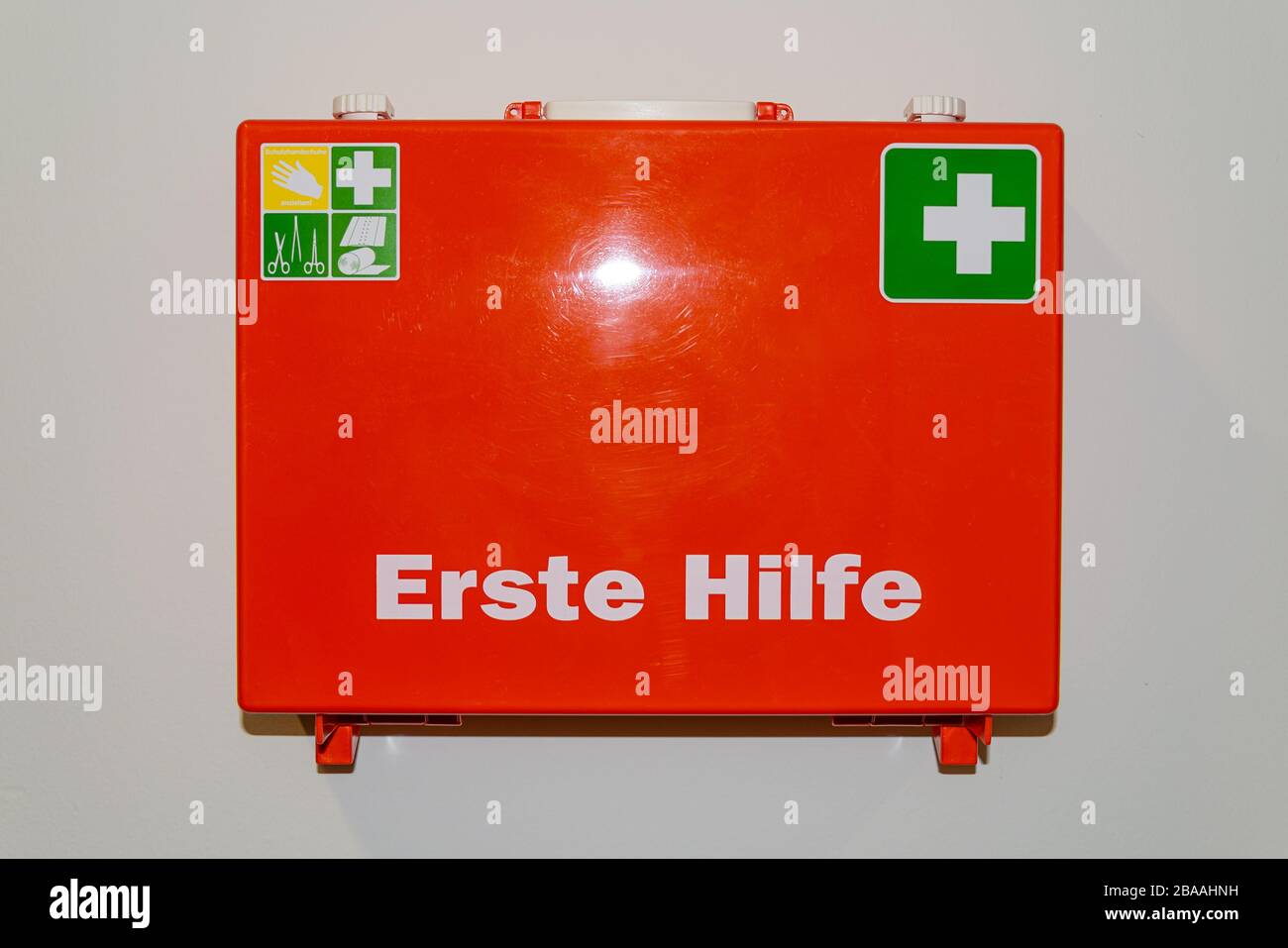 Orange first aid case labeled in German language “First Help” hanging ...