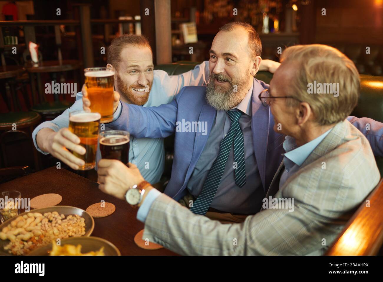 Men in bar celebrating successful hi-res stock photography and images ...