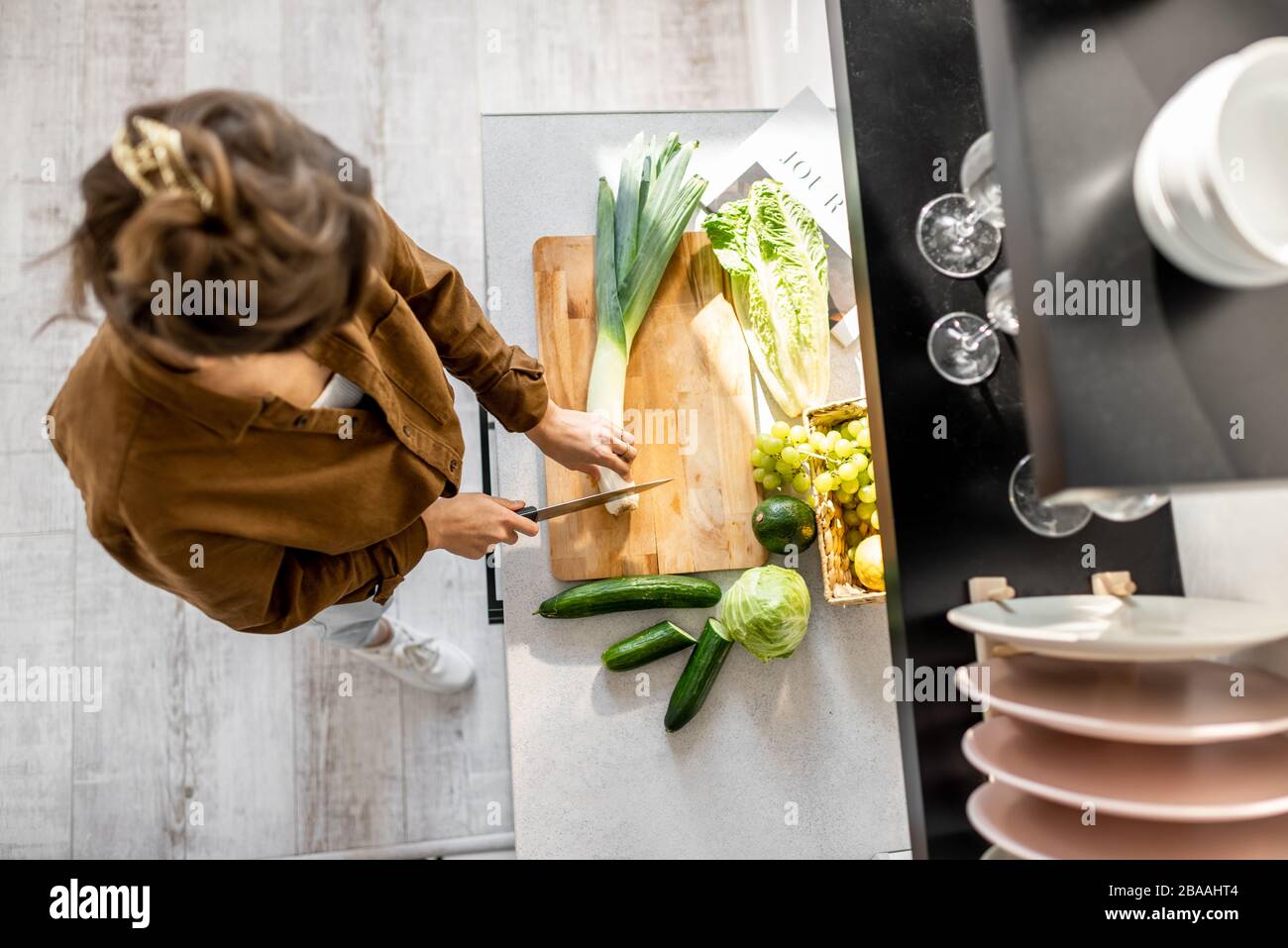 Woman cooking some food, cutting fresh ingredients on the cutting board ...
