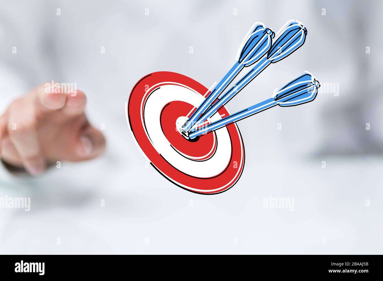 hand holding a target with darts hitting the center over white ...