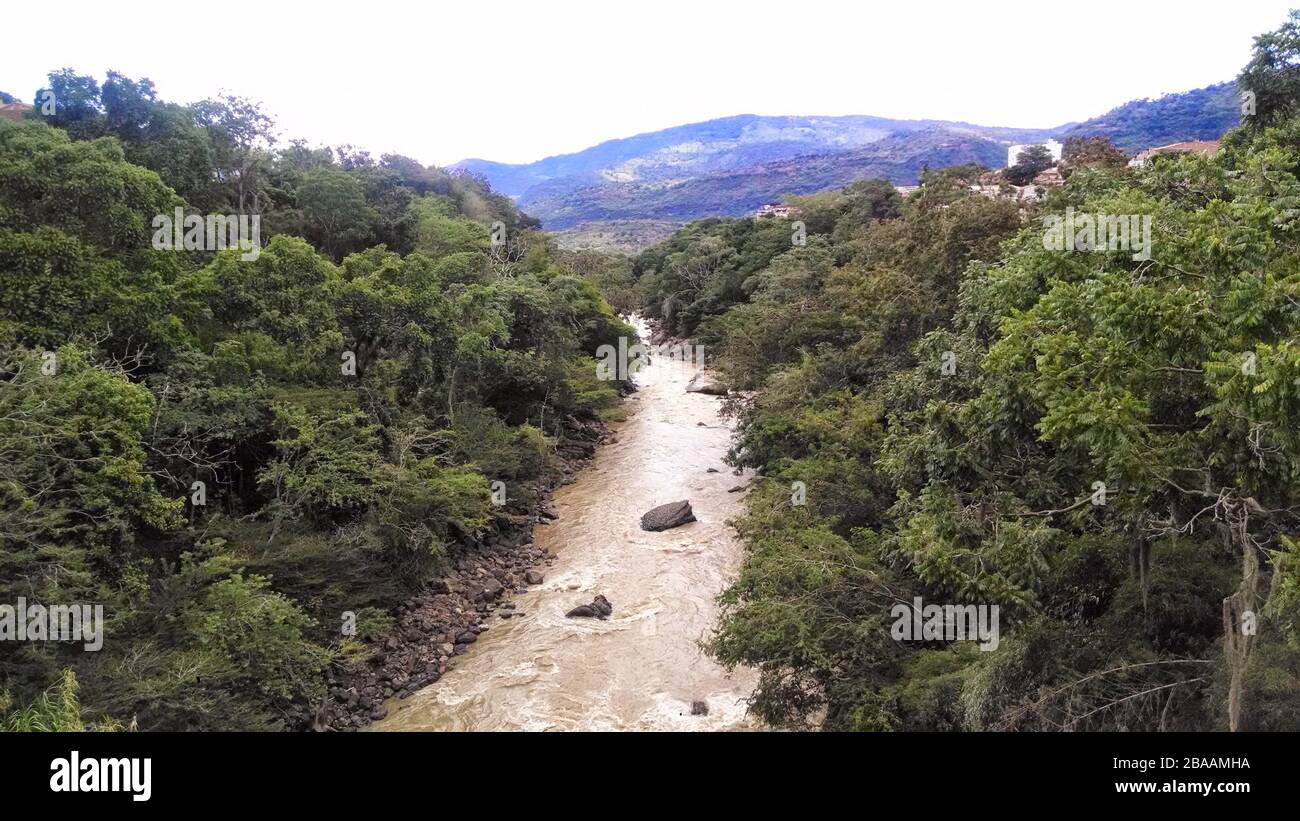 Dirty river surrounded by greenery and hills under the sunlight at ...