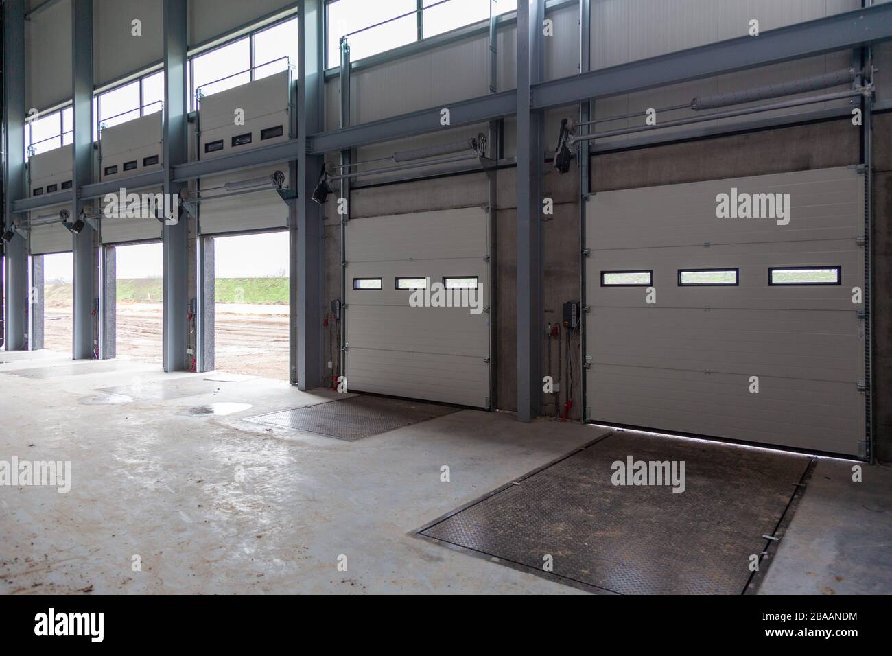 Row of loading bays in a warehouse with open and closed doors Stock ...