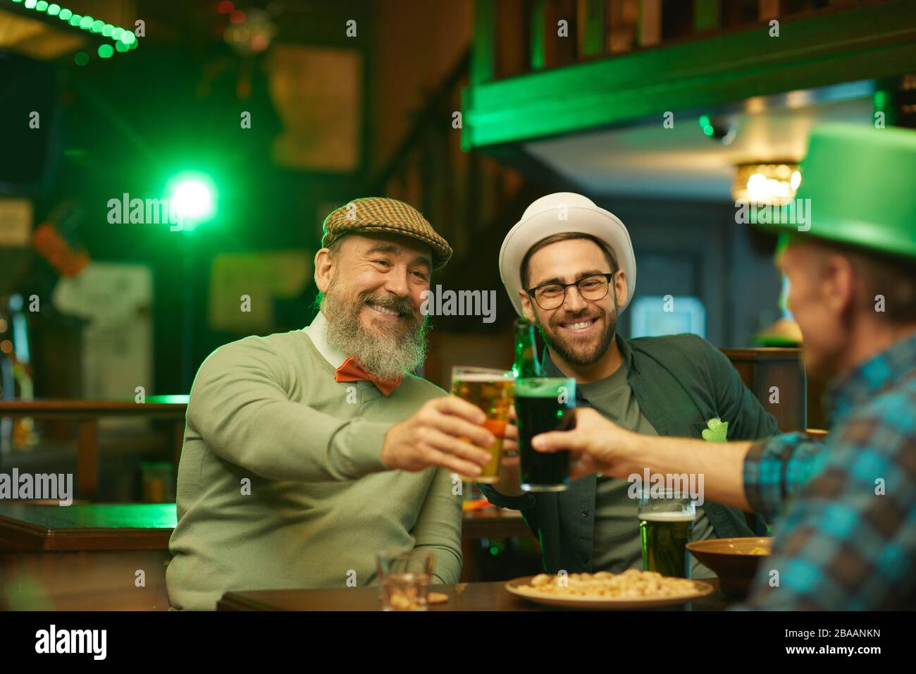 Happy men drinking beer together while celebrating holiday in the pub ...