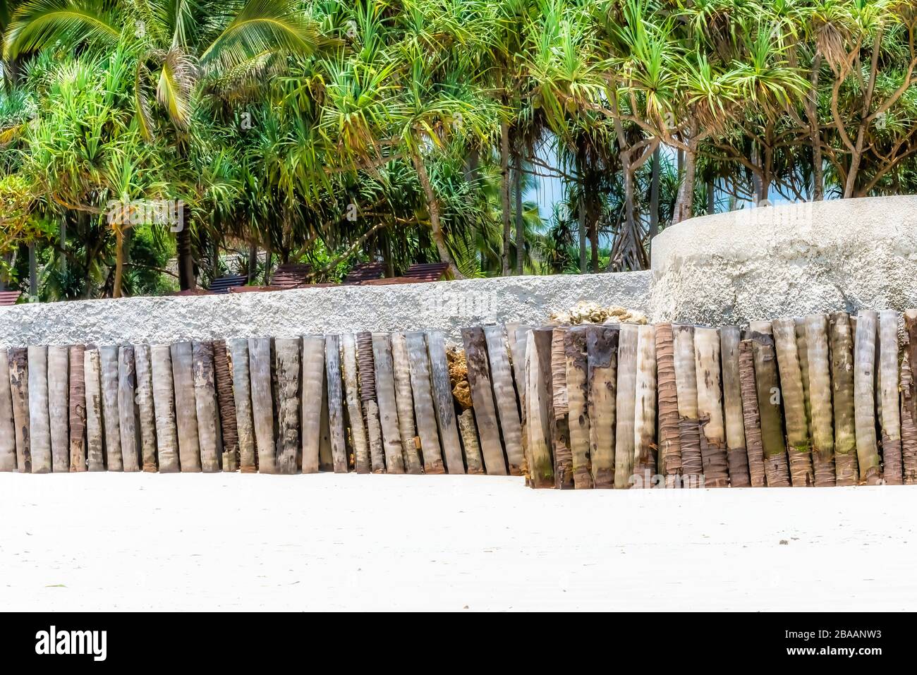 Small fence made of wooden docks and palms in the background Stock ...