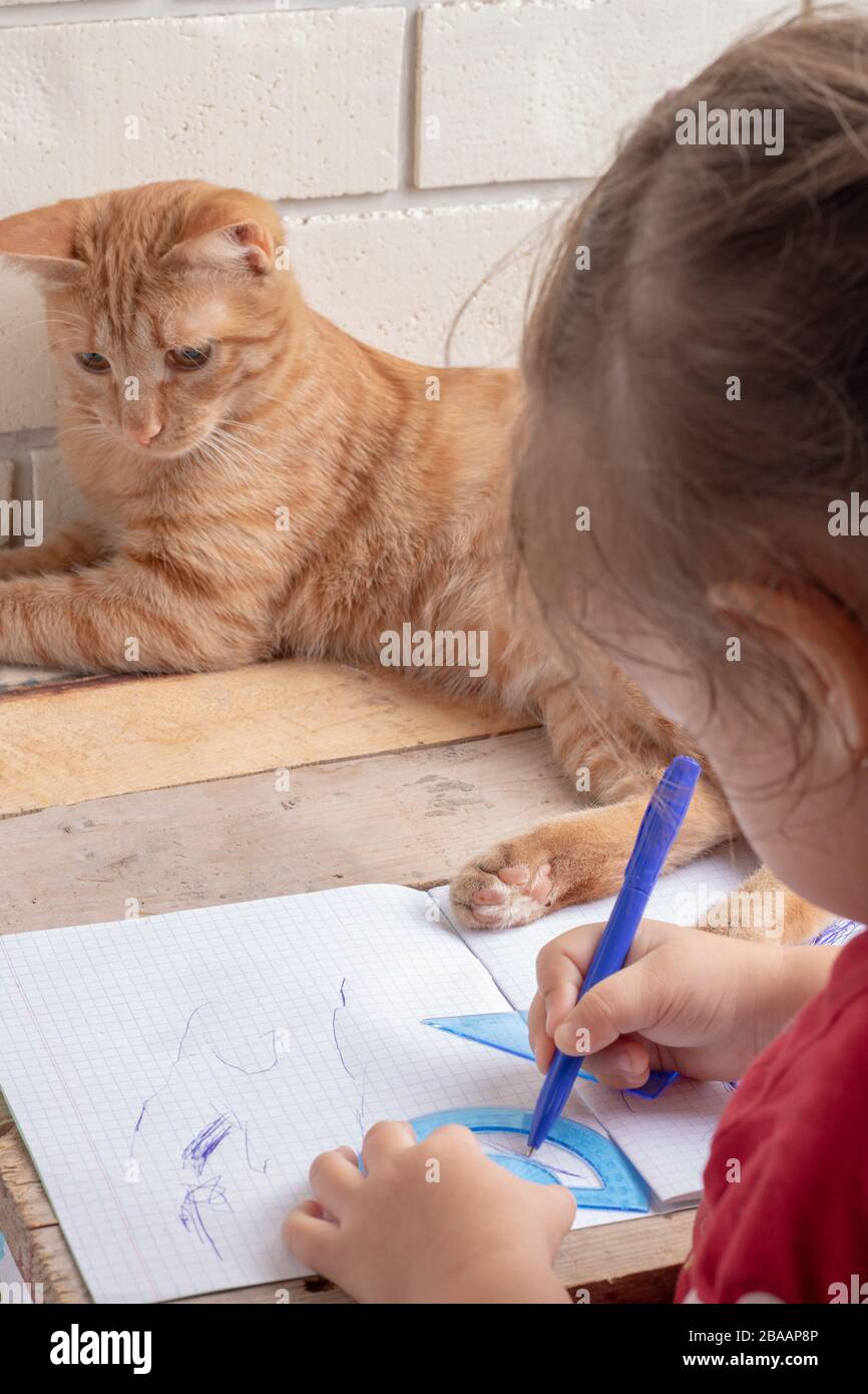 Girl doing homework, writing with pen. Vertical Stock Photo - Alamy