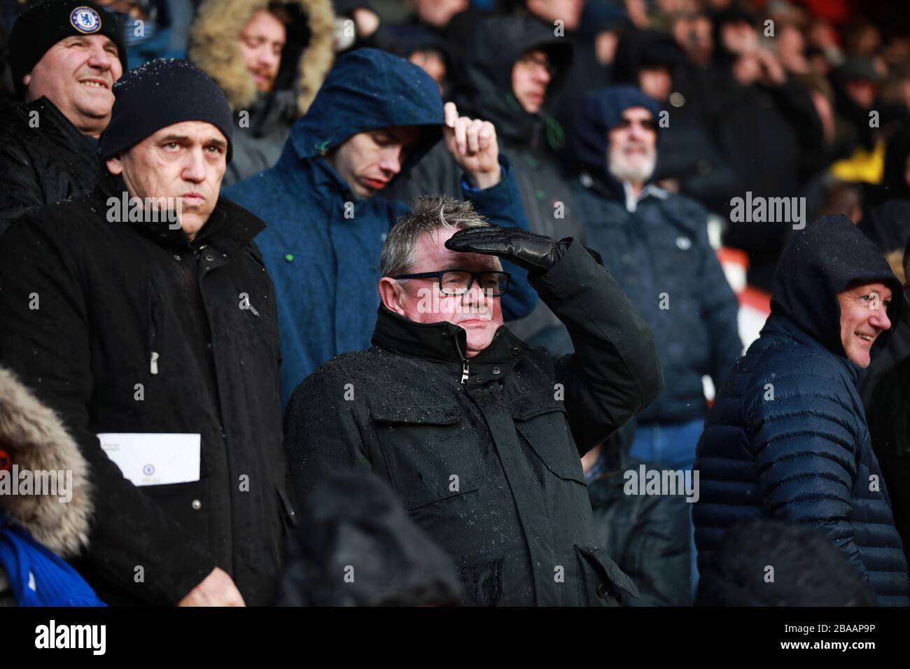 A Chelsea supporter shields himself from a sudden hail storm Stock ...